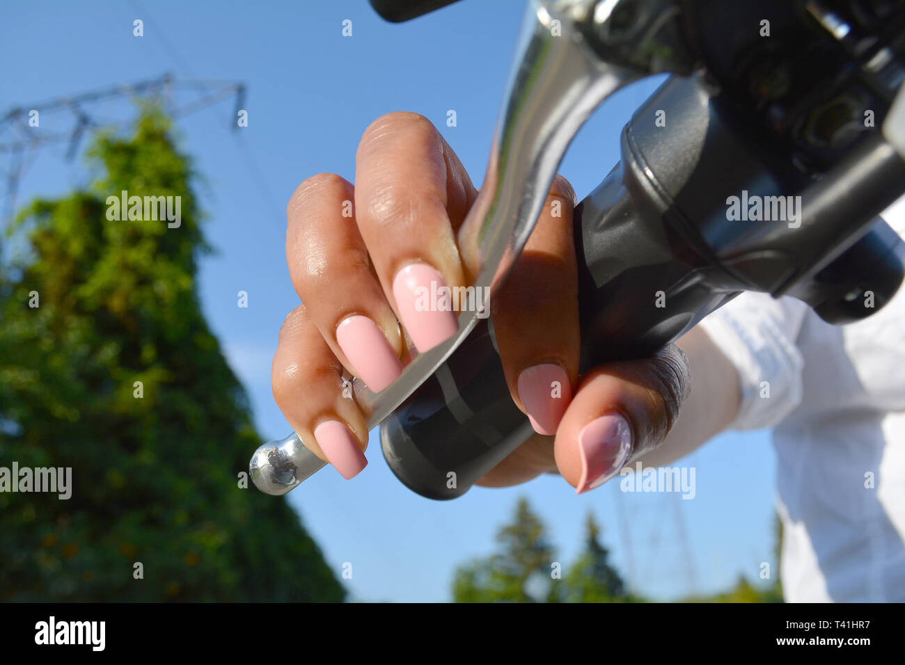 Woman hand with bright pink nails on the bicycle handle. Healthy life ...