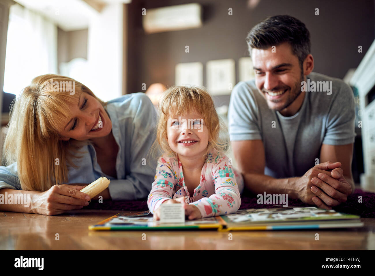 Happy cute female child with parents at home Stock Photo - Alamy