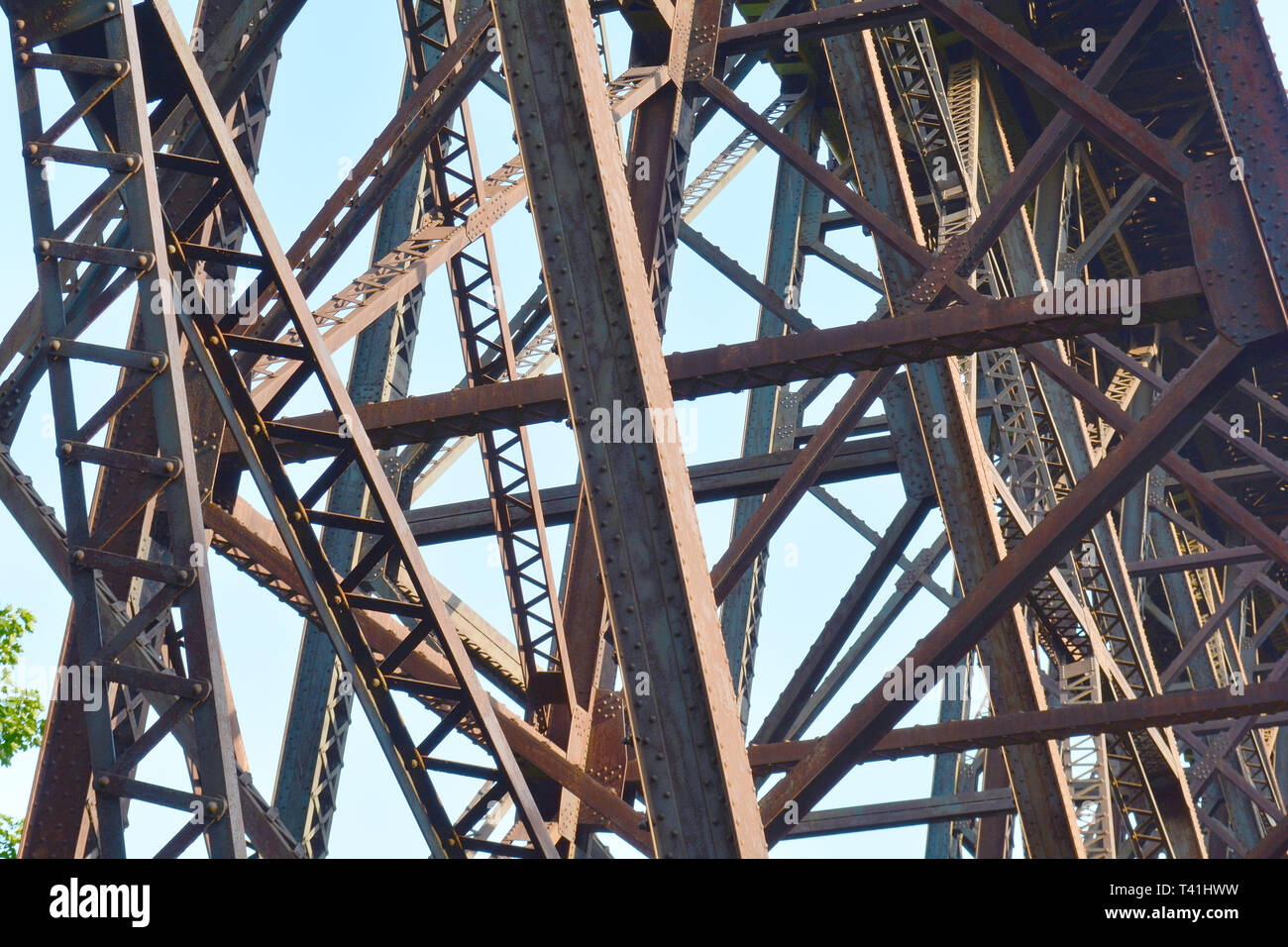 Metal rusty brown rail road bridge debris from below. Railway across ...