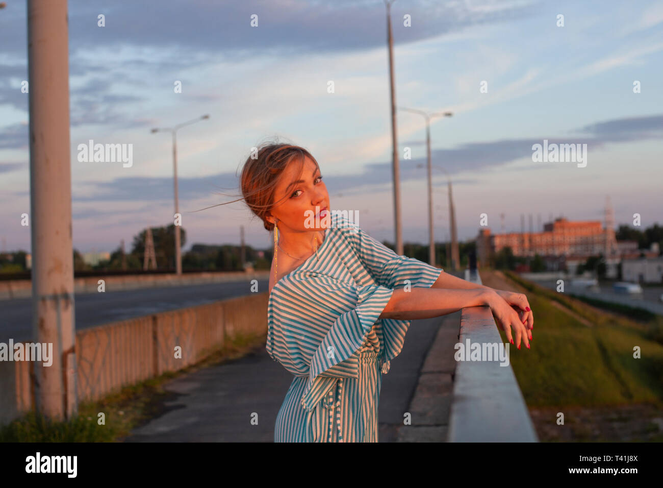 girl stands leaning on the railing of the bridge Stock Photo - Alamy