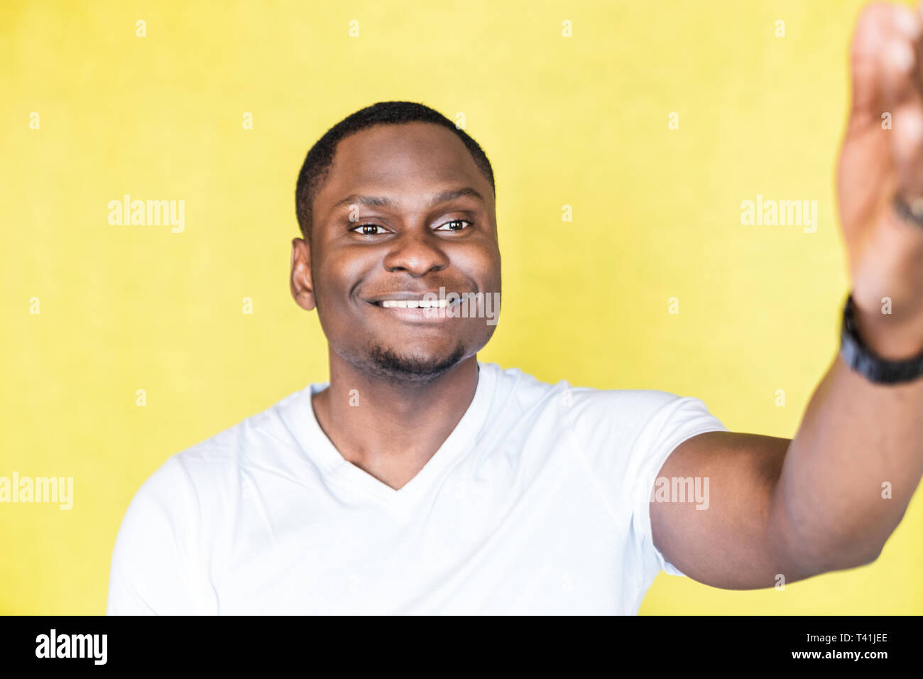 Portrait of a smiling African American man with raised hand Stock Photo ...