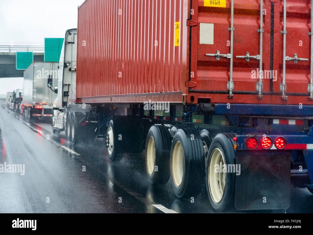 Convoy of different big rigs semi trucks with commercial cargo in semi ...