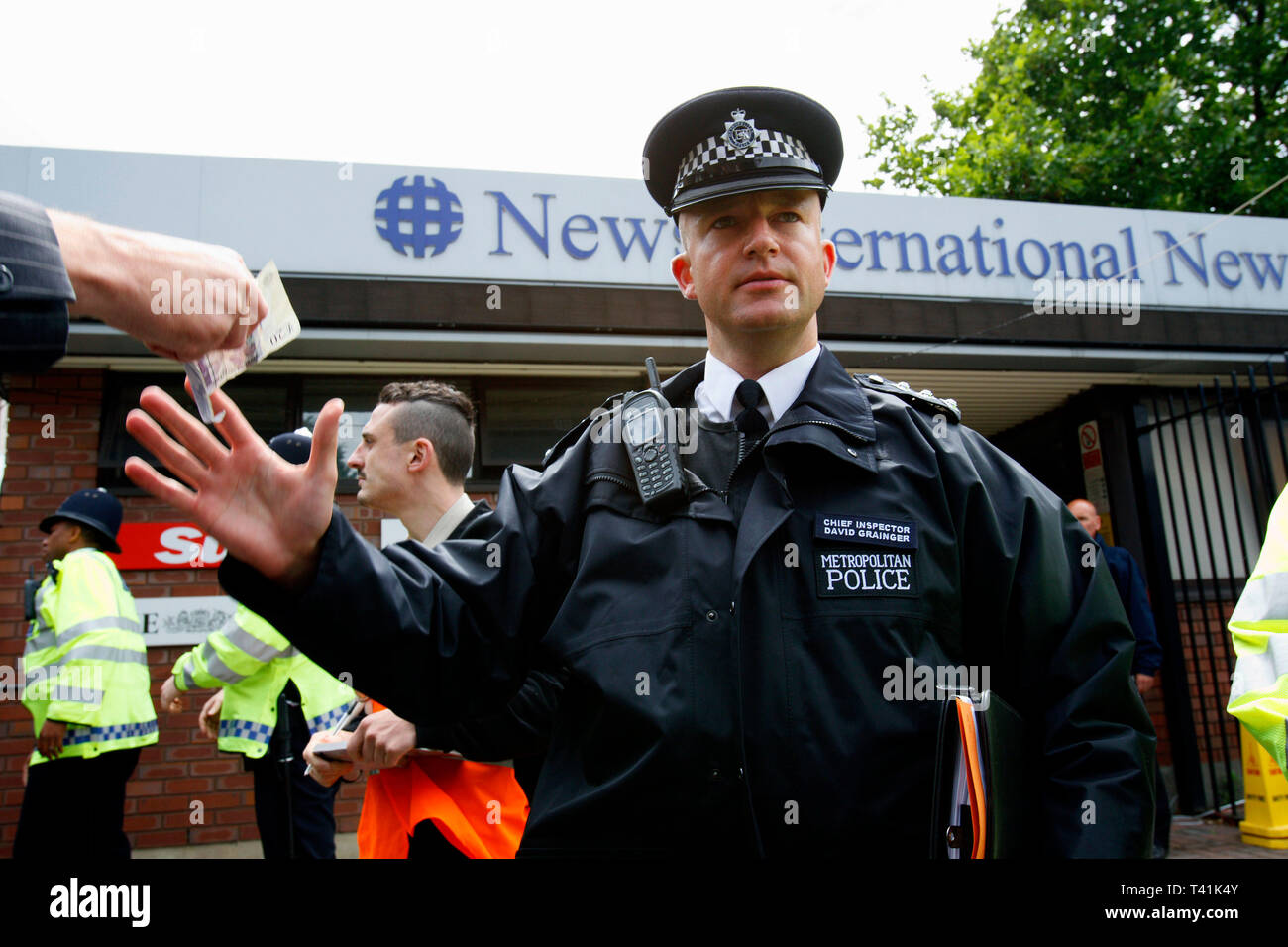 Police officers outside News International during the News of the World ...
