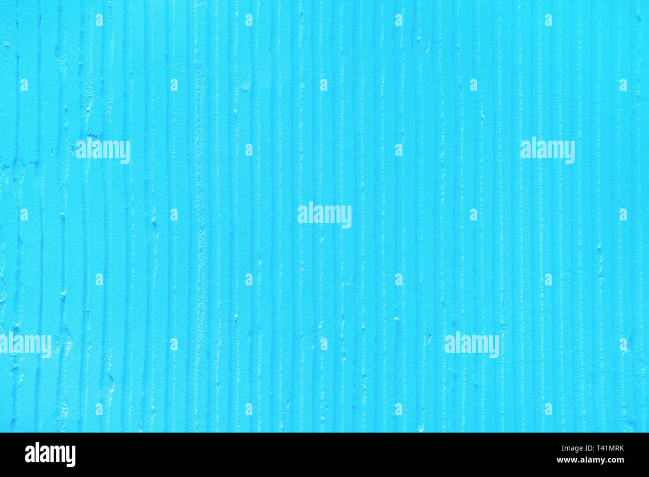 Closeup of the wall with a decorative blue colored plaster vertical ...