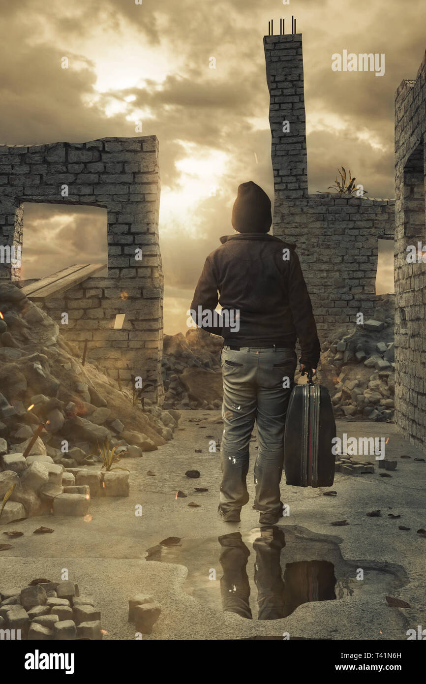 back of homeless man with suitcase in the hand in front of damaged ...