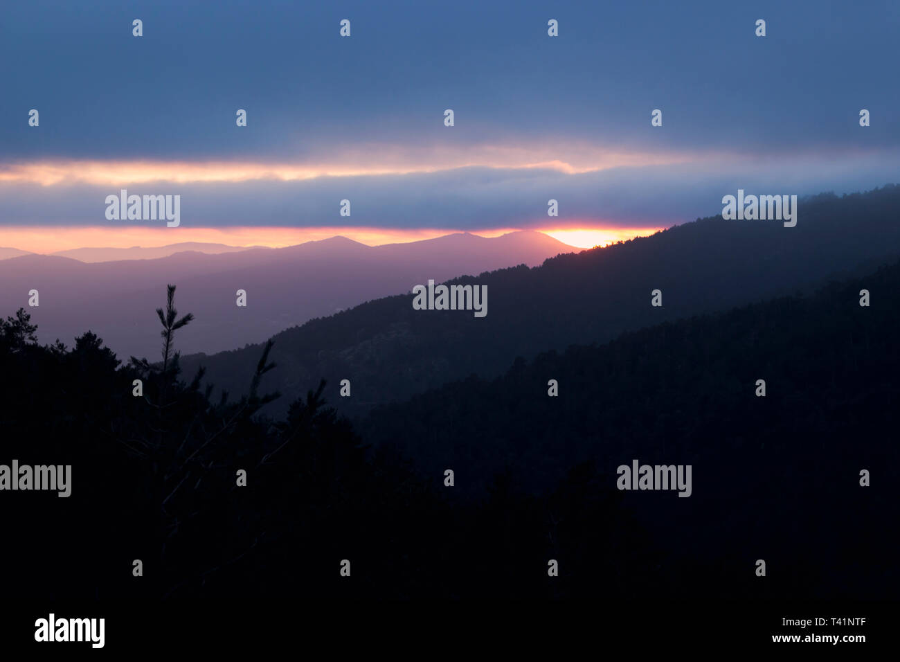 Nice sunset between mountains and forests Stock Photo - Alamy