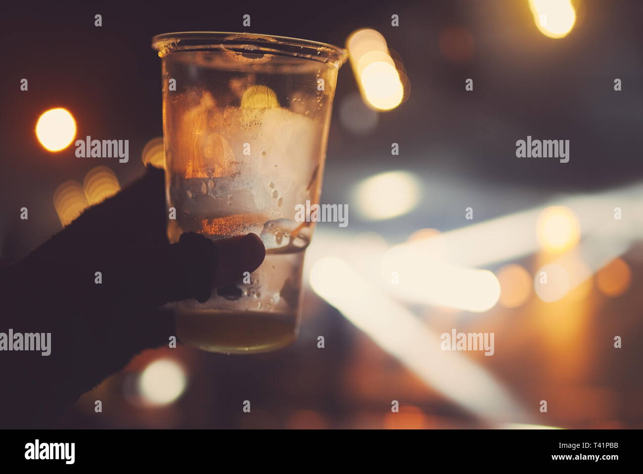 Hand Holding Plastic Beer at Night with Concert Lights Stock Photo - Alamy