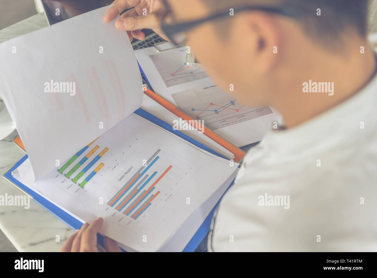 Rear view of office man reading report Stock Photo - Alamy