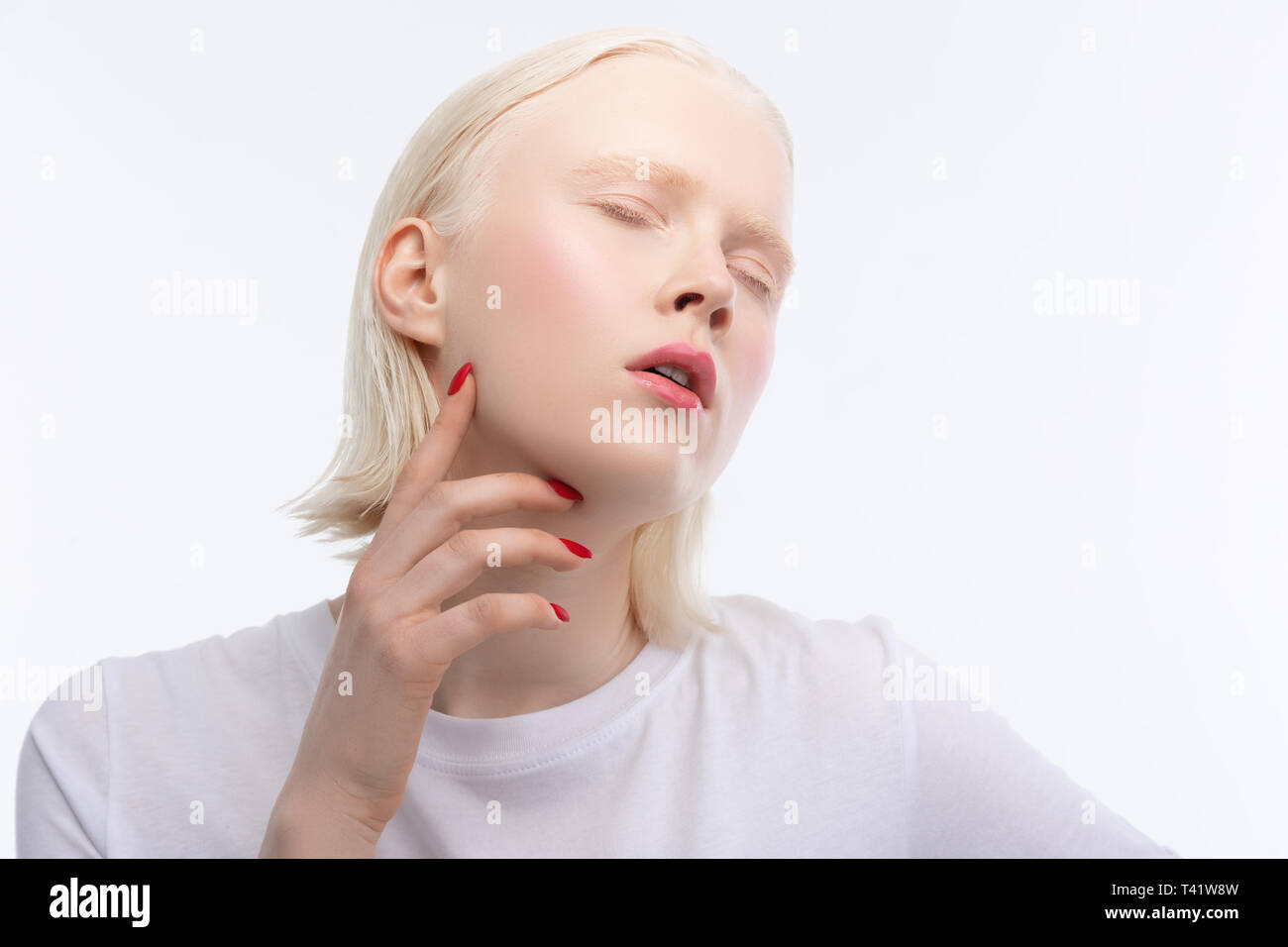 Closing eyes. Professional model with red nail art closing eyes while ...
