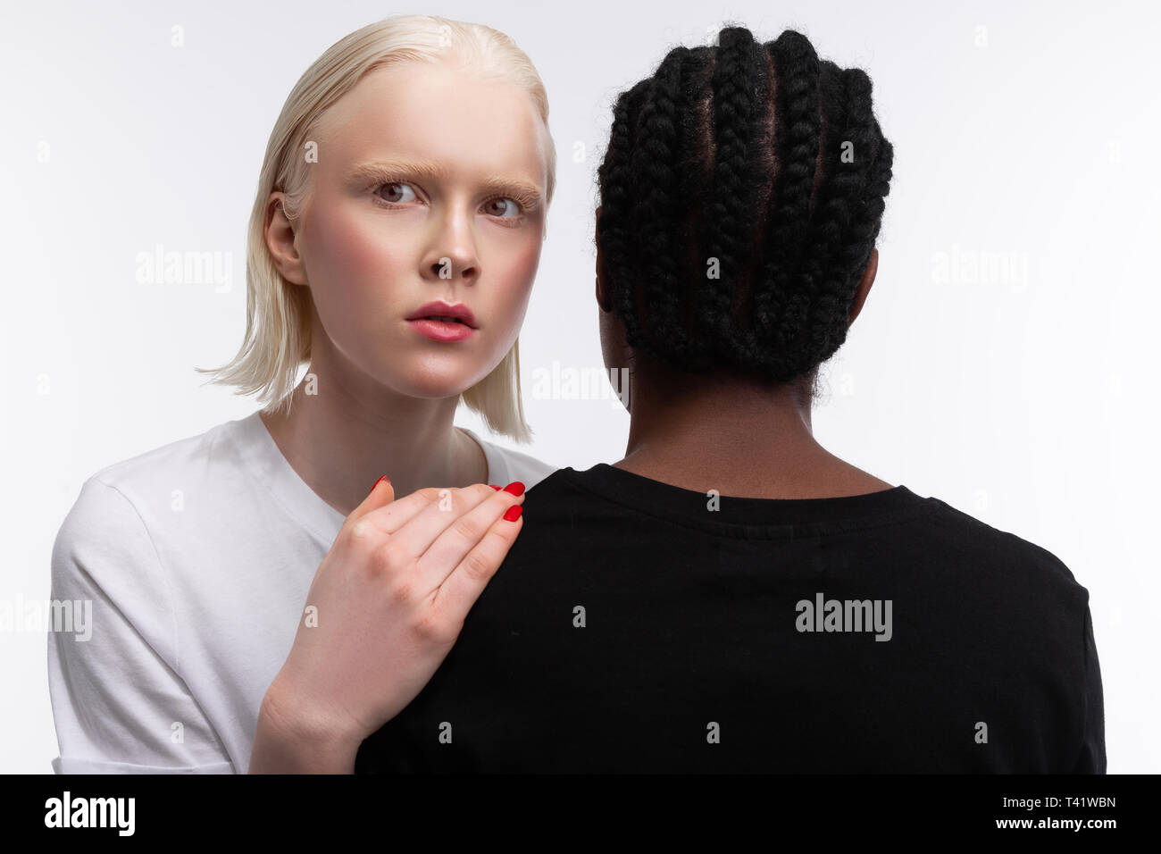Hugging African-American. Woman with white skin and rosy cheeks hugging ...