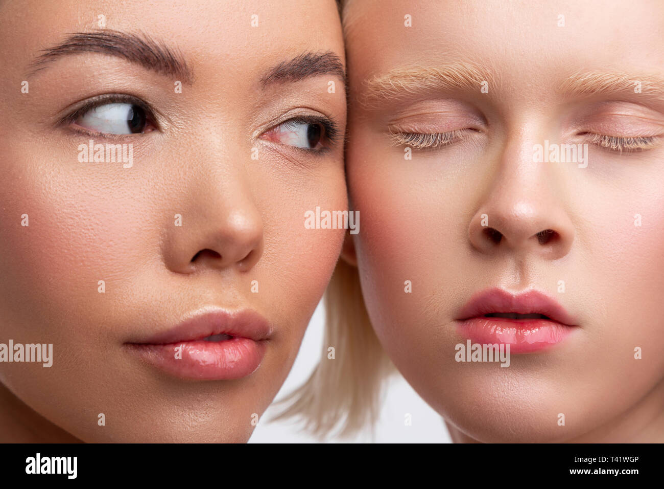 Amazing appearance. Close up of faces of two beautiful young women with ...
