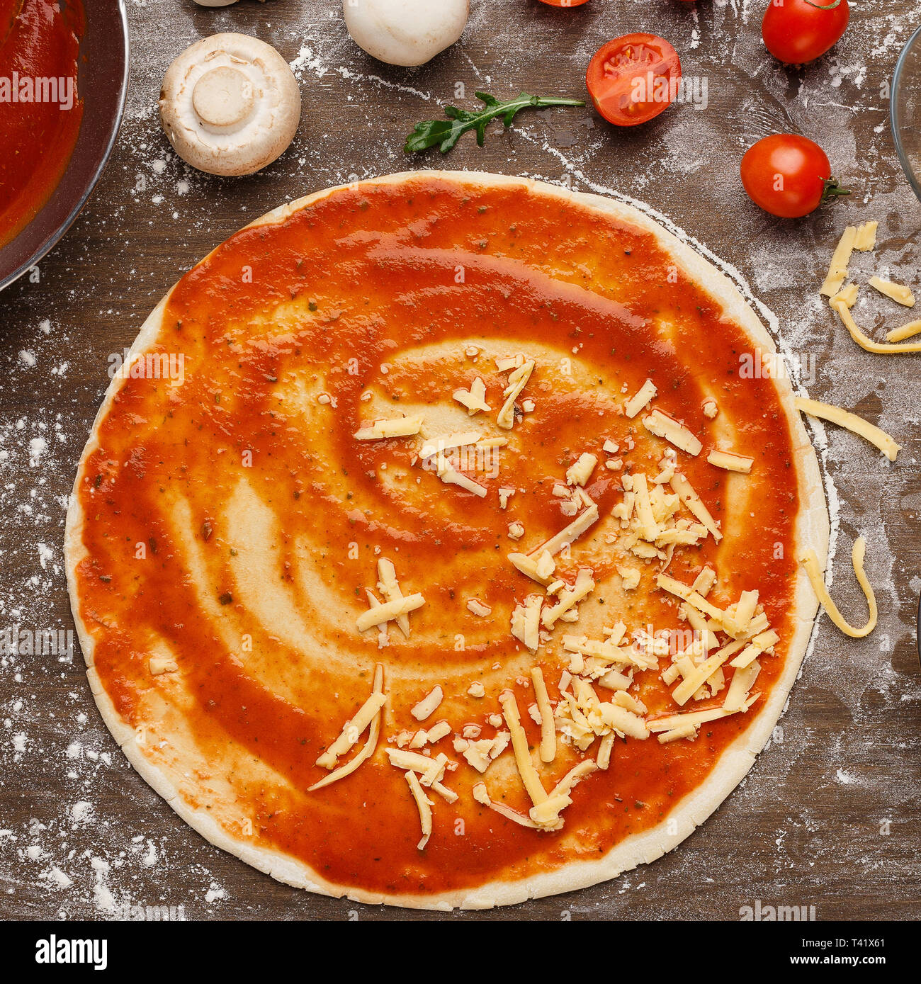 Process of cooking. Unbaked pizza with grated cheese Stock Photo - Alamy