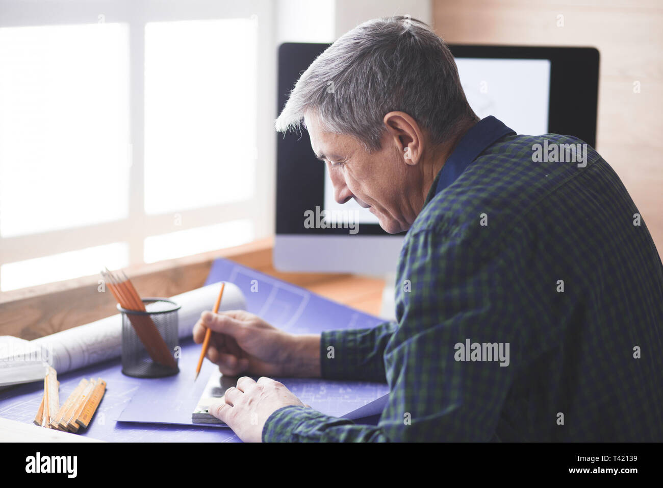 Engineer carpenter working on laptop and sketching project Stock Photo ...