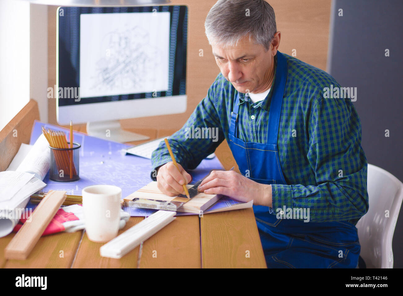 Engineer carpenter working on laptop and sketching project Stock Photo ...