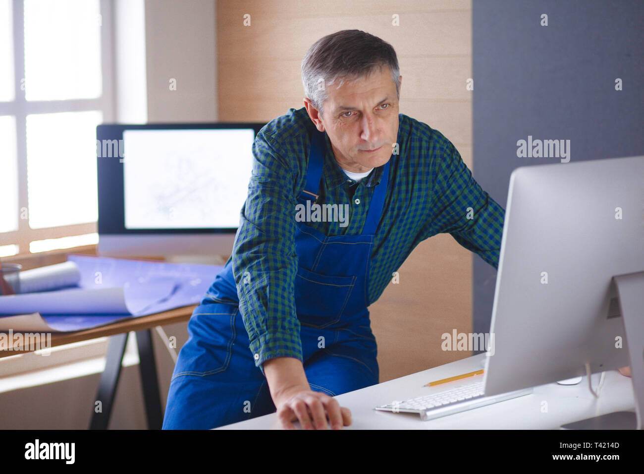 Engineer carpenter working on laptop and sketching project Stock Photo ...