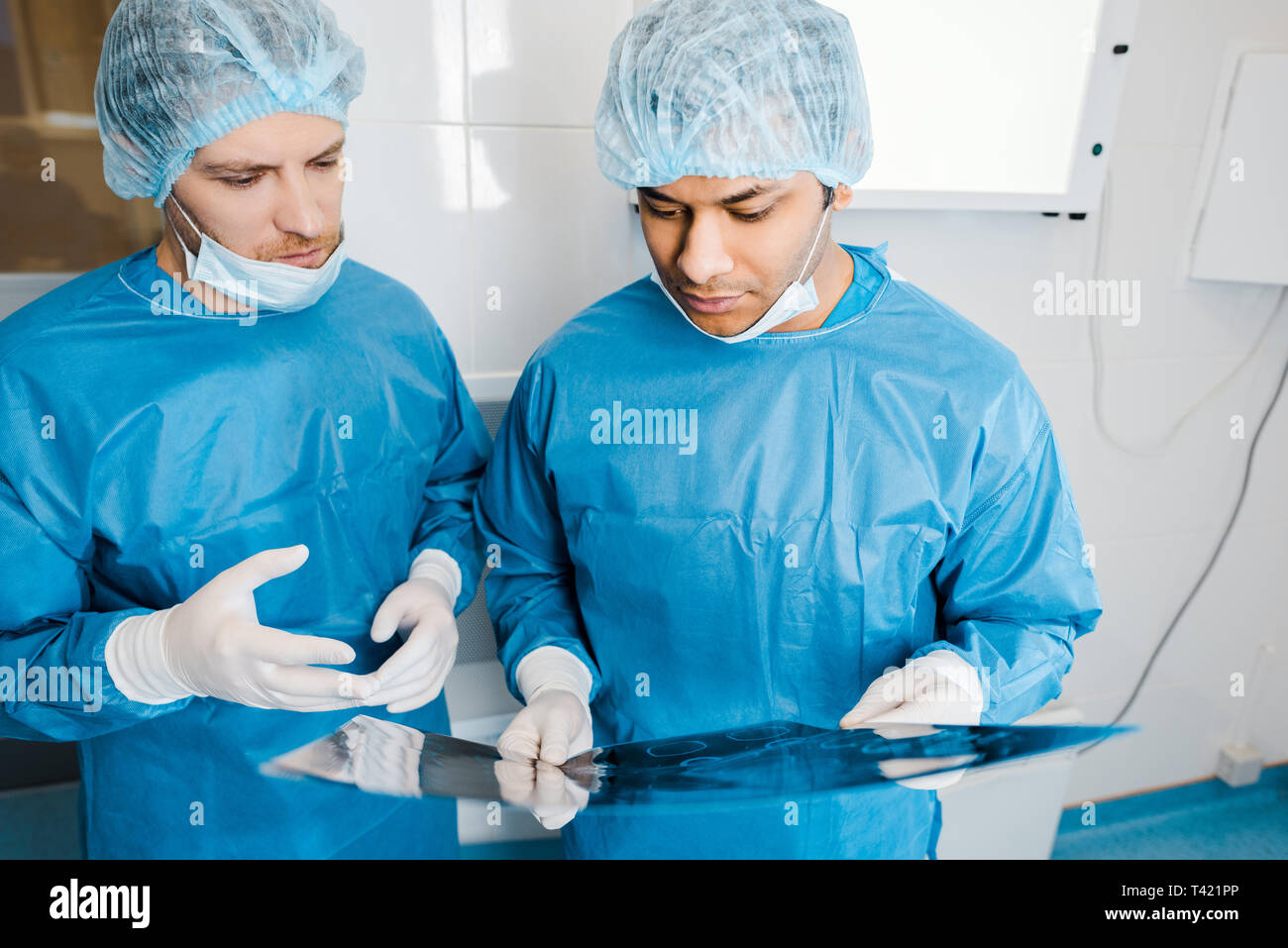 good-looking doctors in uniforms and medical masks talking about x-ray ...