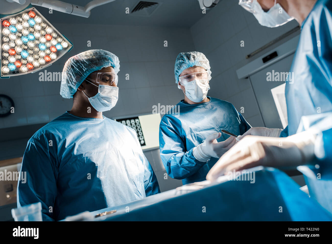 doctors and nurse in uniforms and medical masks in operating room Stock ...