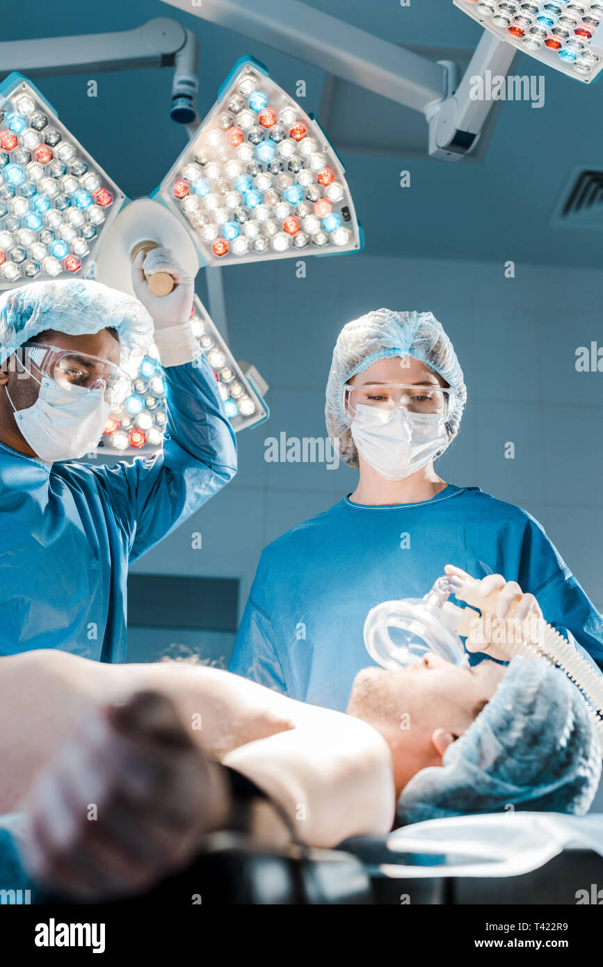 selective focus of doctor and nurse in uniforms and medical caps ...