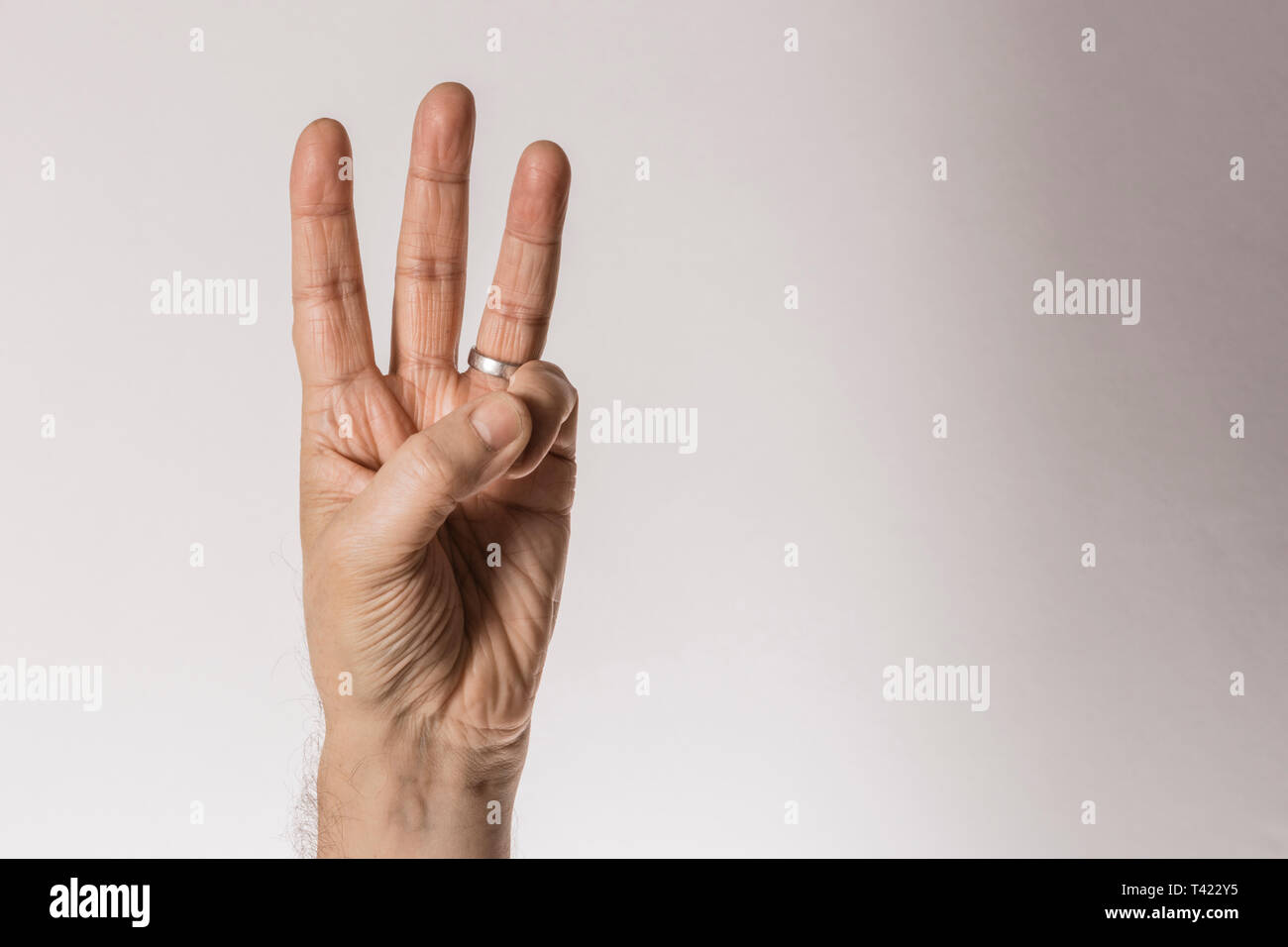 Man`s hand gesture, counting number three, isolated on white background ...