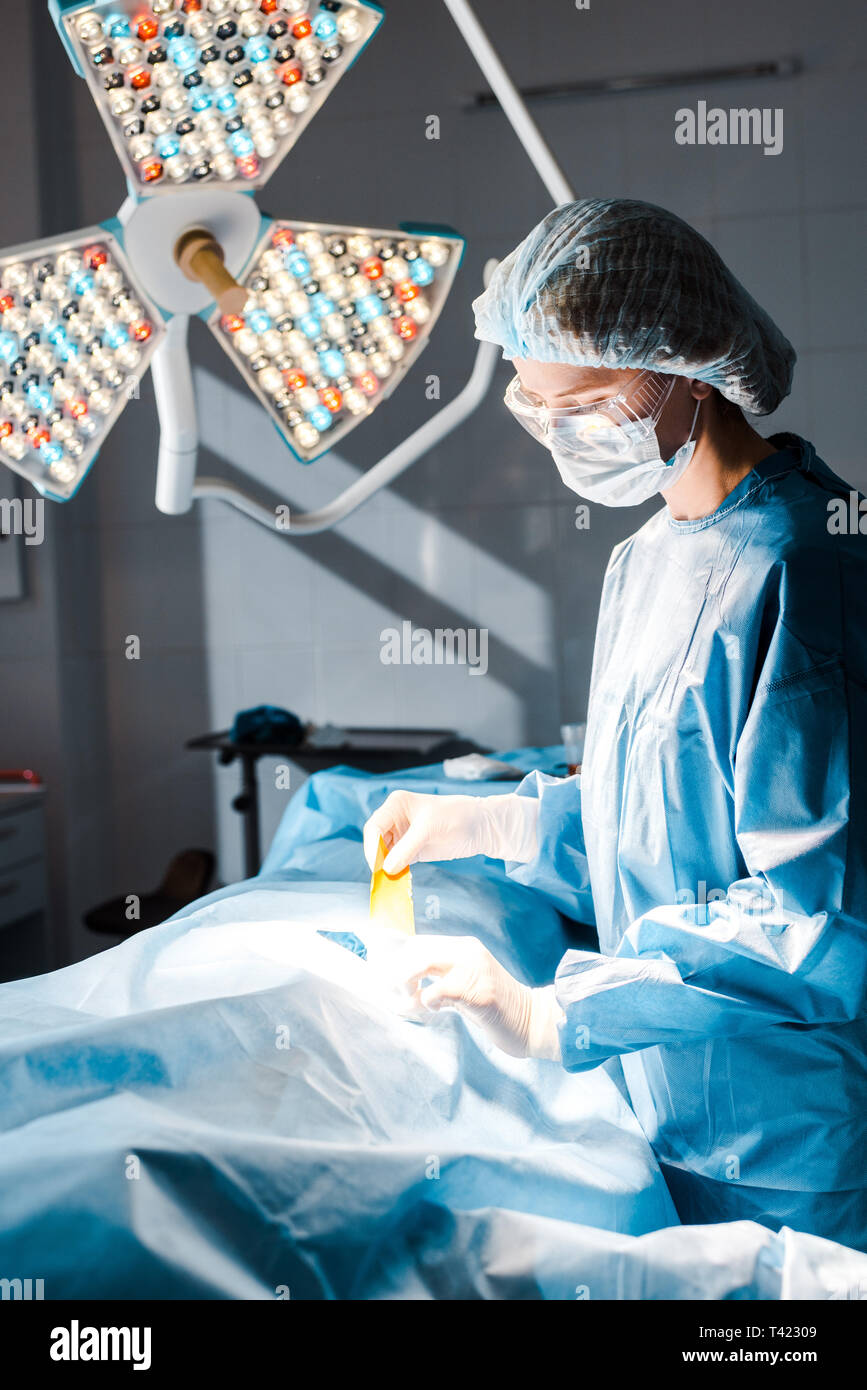 nurse in uniform and medical cap holding strip in operating room Stock ...