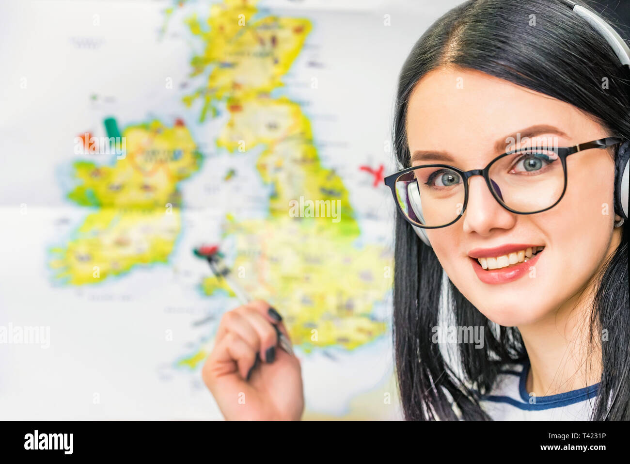 Young beautiful girl with headphones and map of England Stock Photo - Alamy