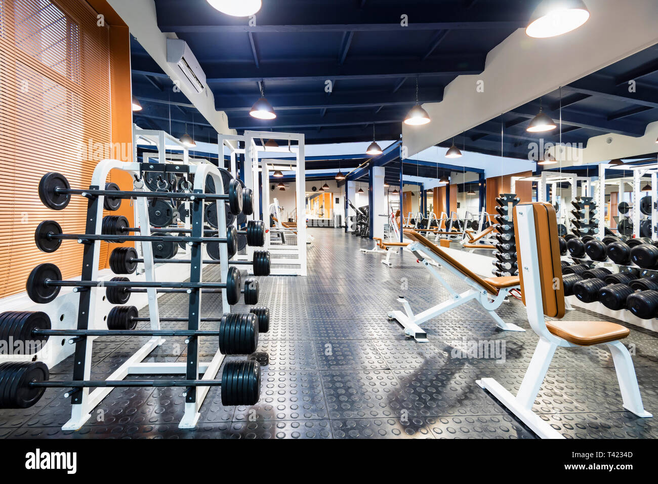 Equipment in modern gym interior. Barbells and weights Stock Photo - Alamy