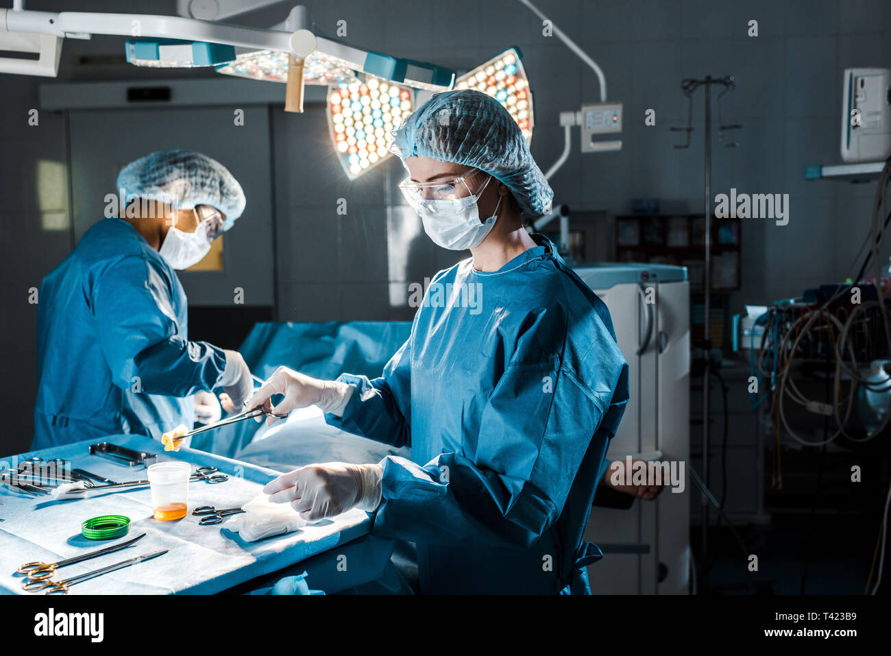 surgeon doing operation and nurse holding tampon in operating room ...