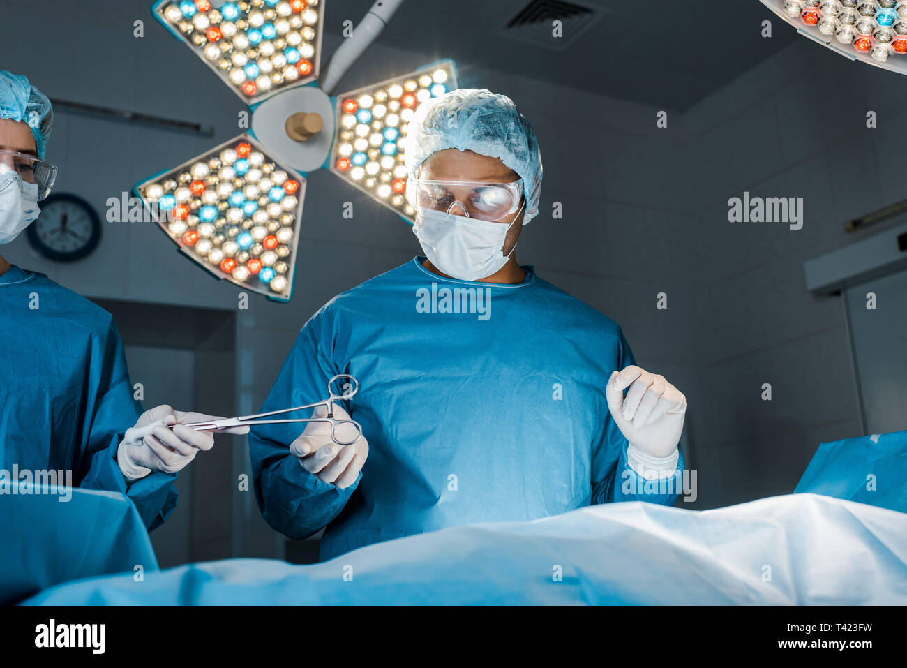 nurse and surgeon in uniforms and medical masks doing operation Stock ...