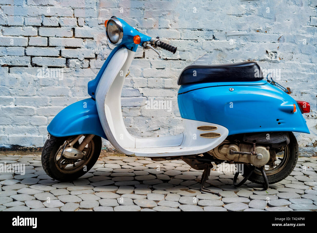 Blue retro scooter parked on city street Stock Photo - Alamy