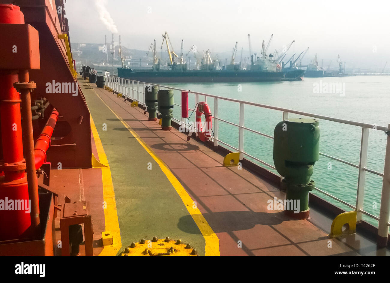 View of the sea and city beach from the port quay. Industrial port with ...
