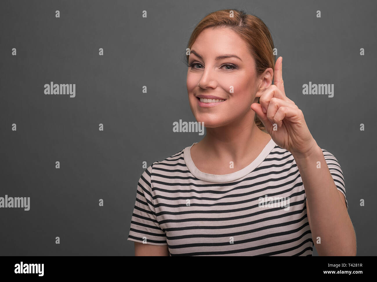 Beautiful smiling blonde woman showing forefinger up. Idea Stock Photo ...