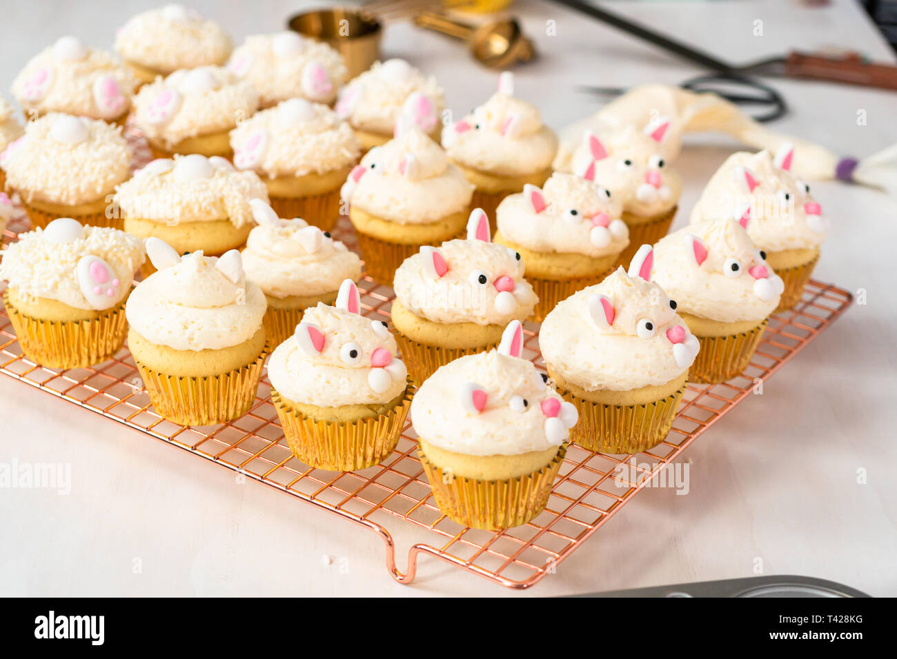 Decorating vanilla cupcakes with a white buttercream icing and bunny ...
