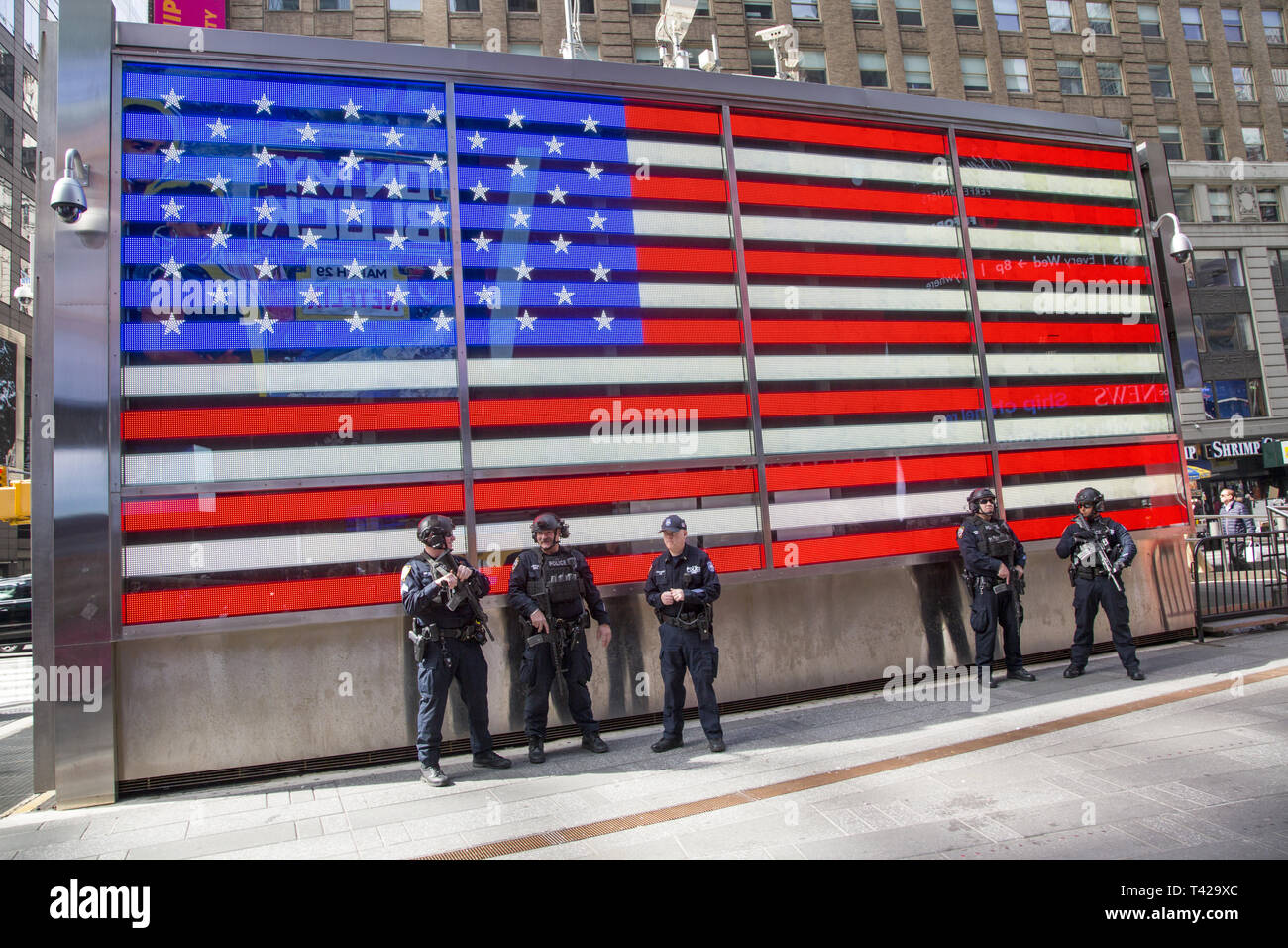 NYPD Police officers carry automatic weapons near the military ...