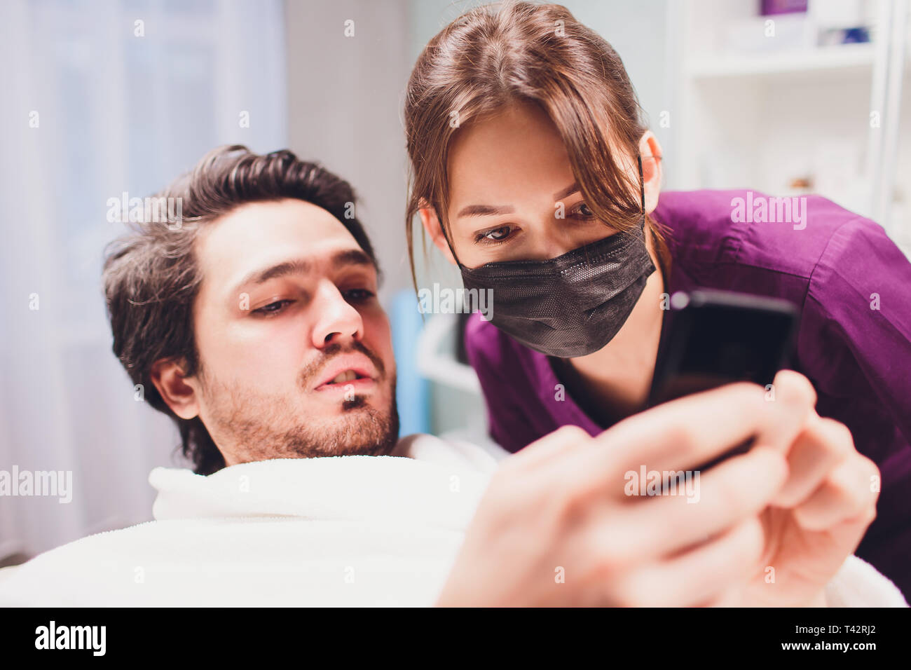 man and doctor before plastic surgery. Doctor holding tablet and ...