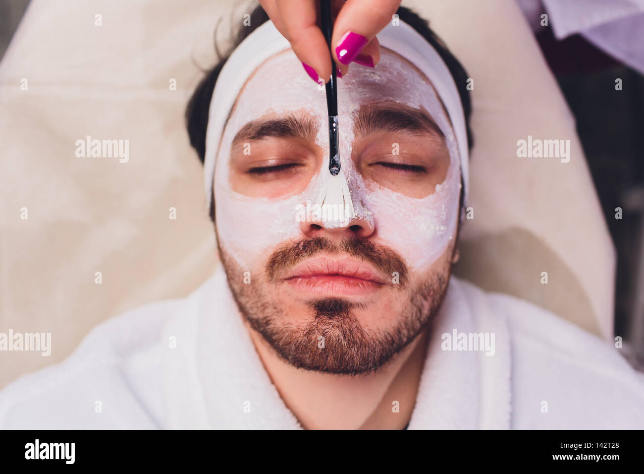 men's cosmetology. the doctor is a cosmetologist in a white robe ...