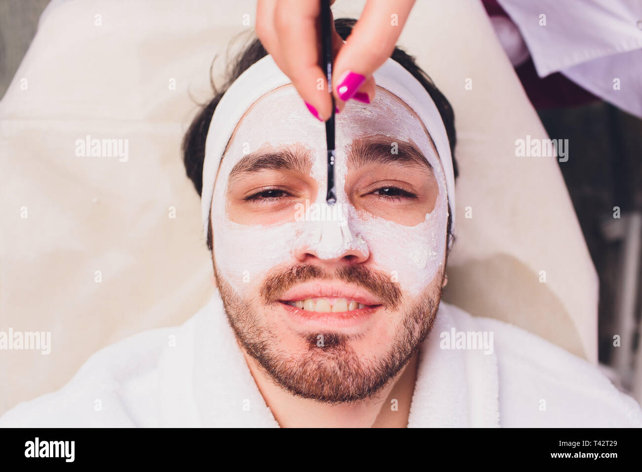 men's cosmetology. the doctor is a cosmetologist in a white robe ...