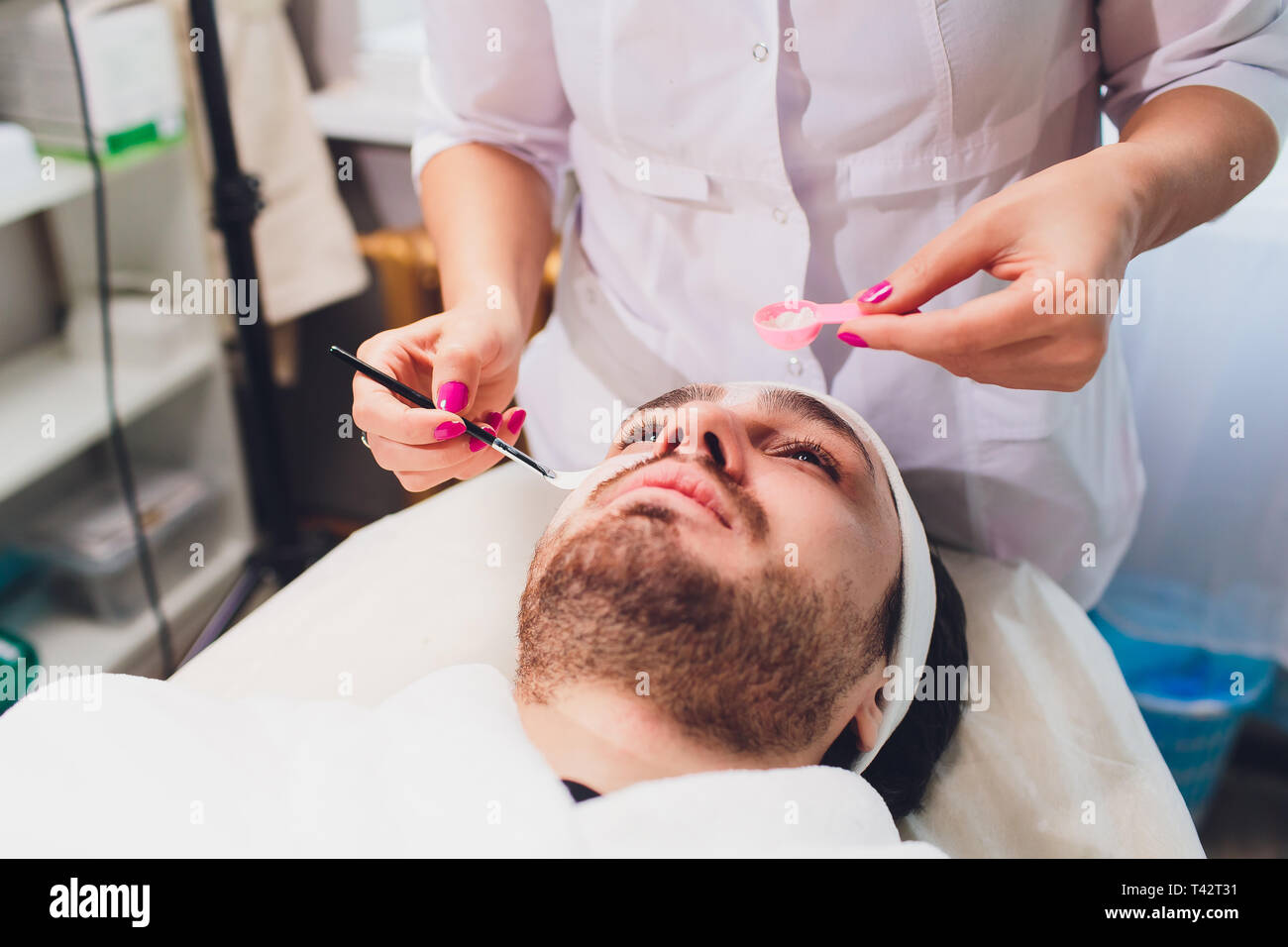 men's cosmetology. the doctor is a cosmetologist in a white robe ...