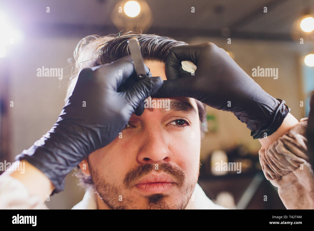 Closeup of process of threading procedure in barber shop. Professional ...