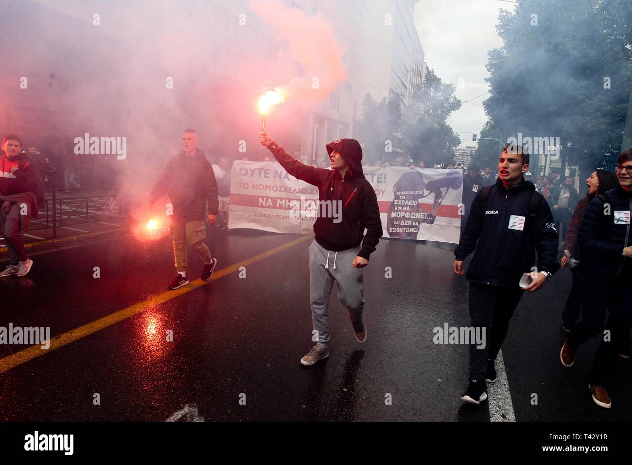 University students hold flares and chant slogans as they participate ...