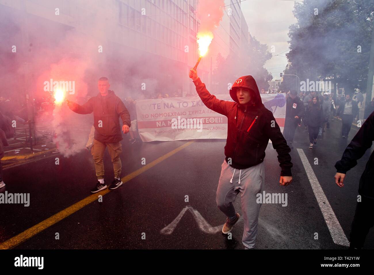 University students hold flares and chant slogans as they participate ...