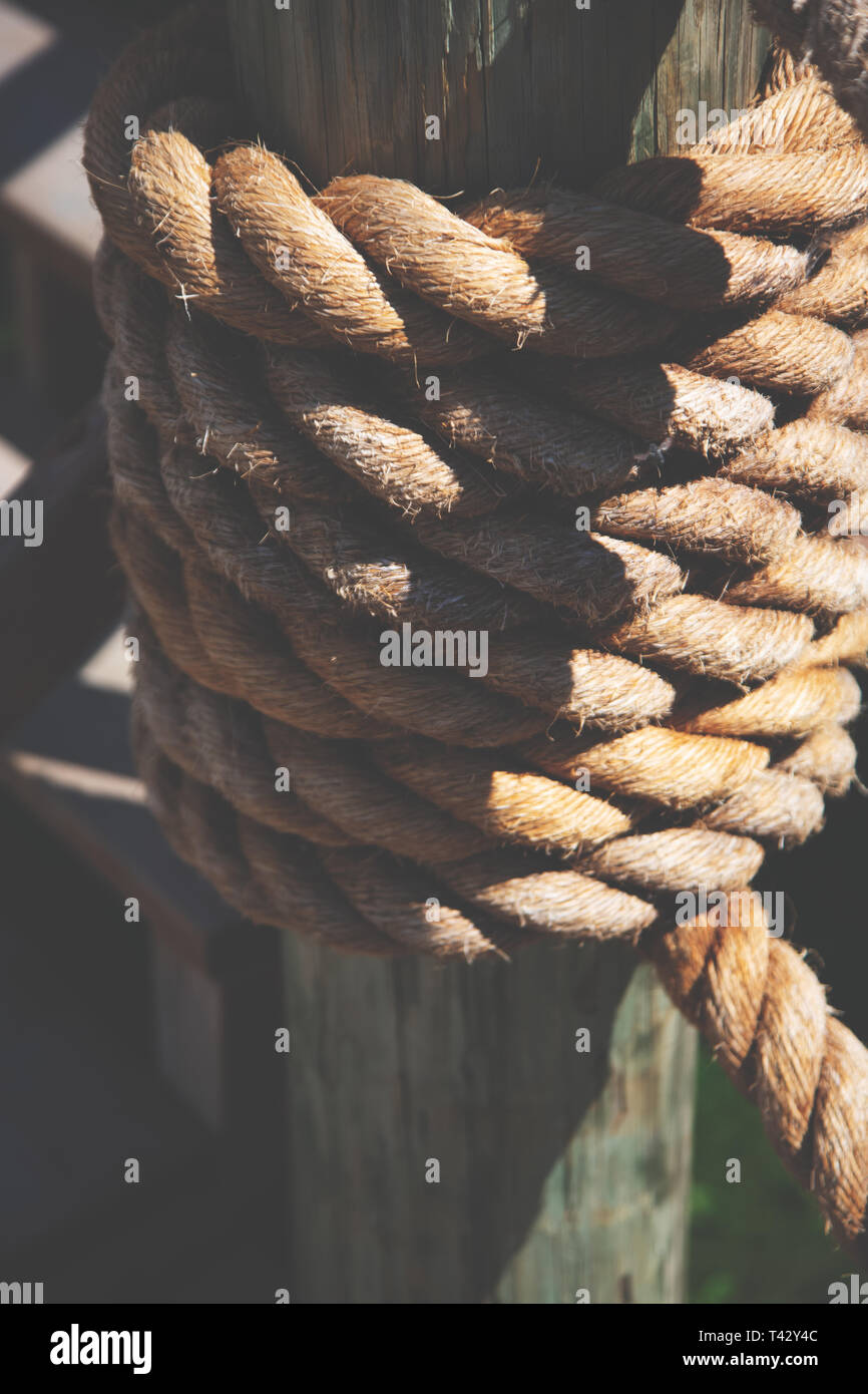A thick rope wrapped neatly around a wooden beam Stock Photo - Alamy