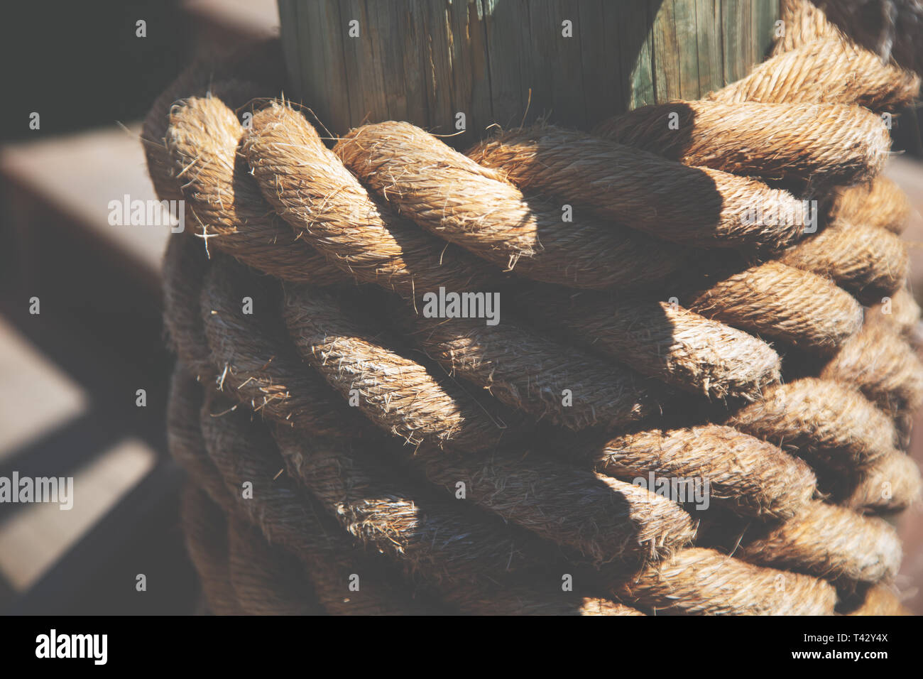 A thick ship rope wrapped neatly around a wooden beam Stock Photo - Alamy