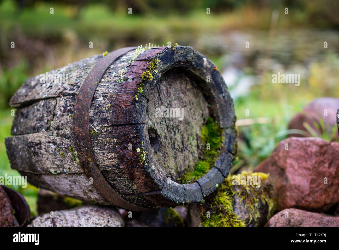 Black clay jug and old wooden barrel on stone pile Stock Photo - Alamy