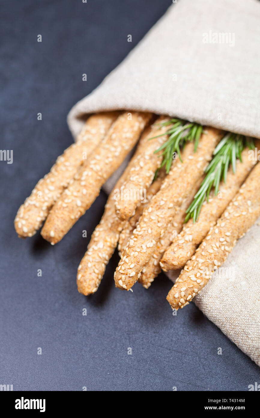 Italian grissini bread sticks with sesame and rosemary herb on black ...