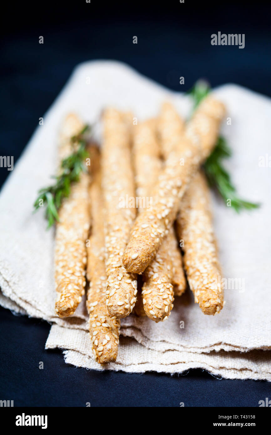 Italian grissini bread sticks with sesame and rosemary herb on black ...