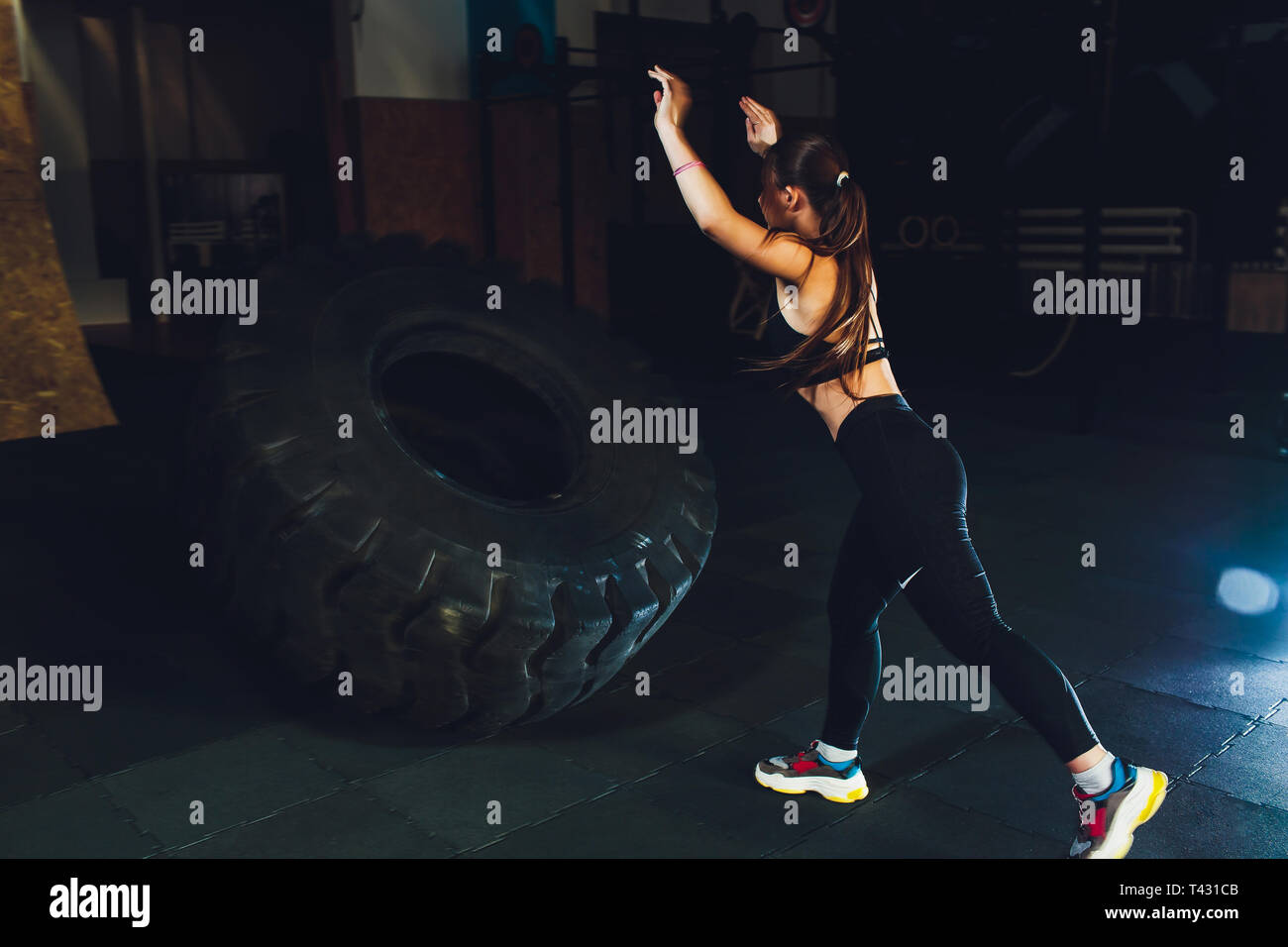 Fitness woman flipping wheel tire in gym. Fit female athlete working ...