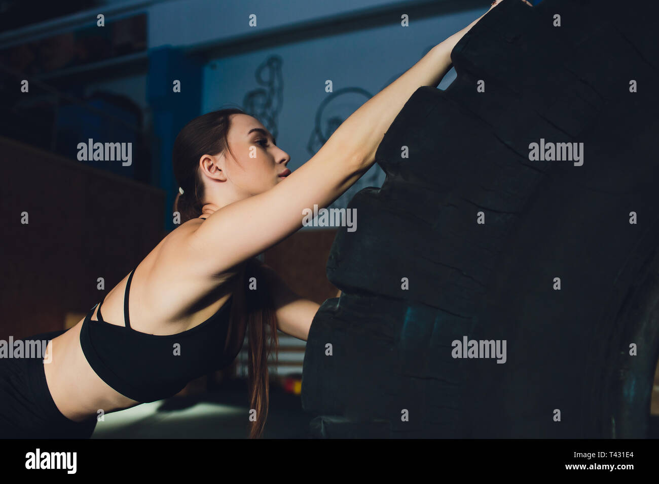 Fitness woman flipping wheel tire in gym. Fit female athlete working ...