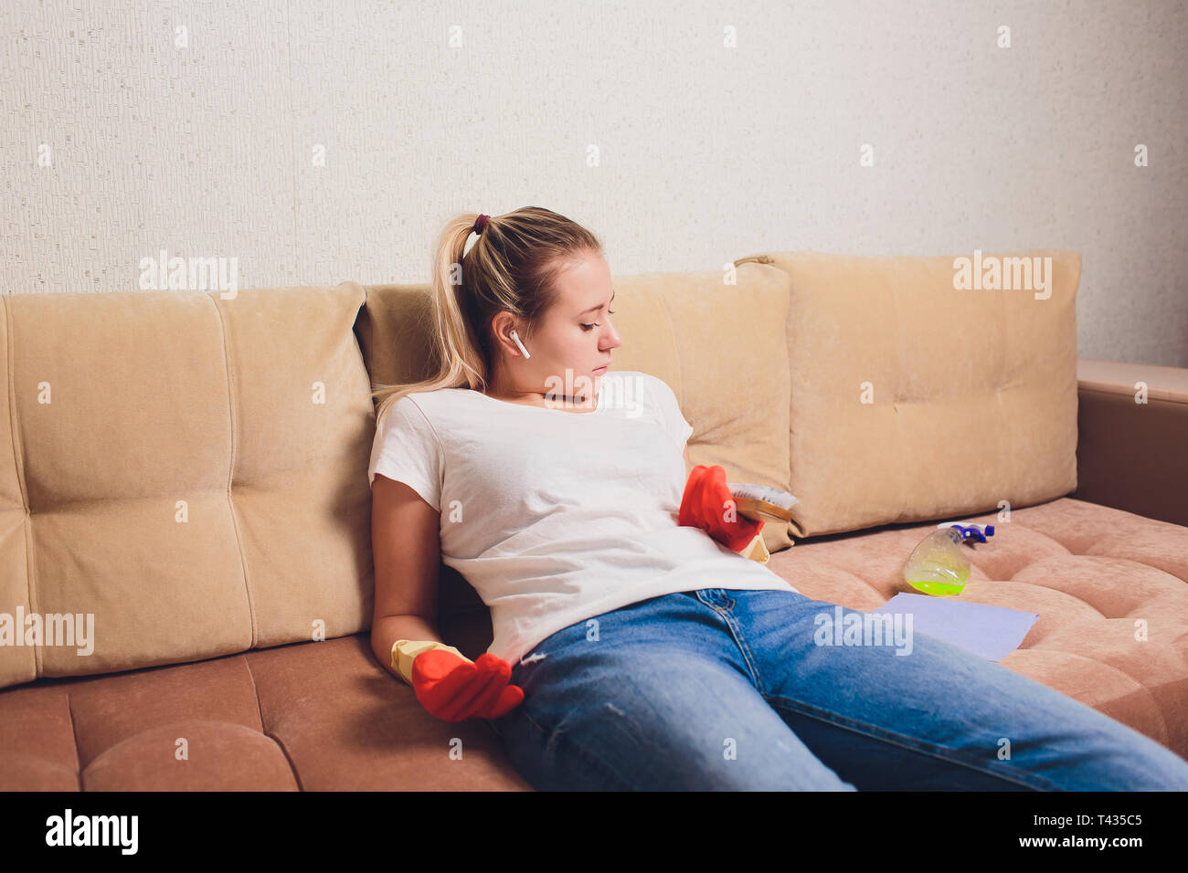 Tired woman having rest after cleaning home, lying on sofa in the ...