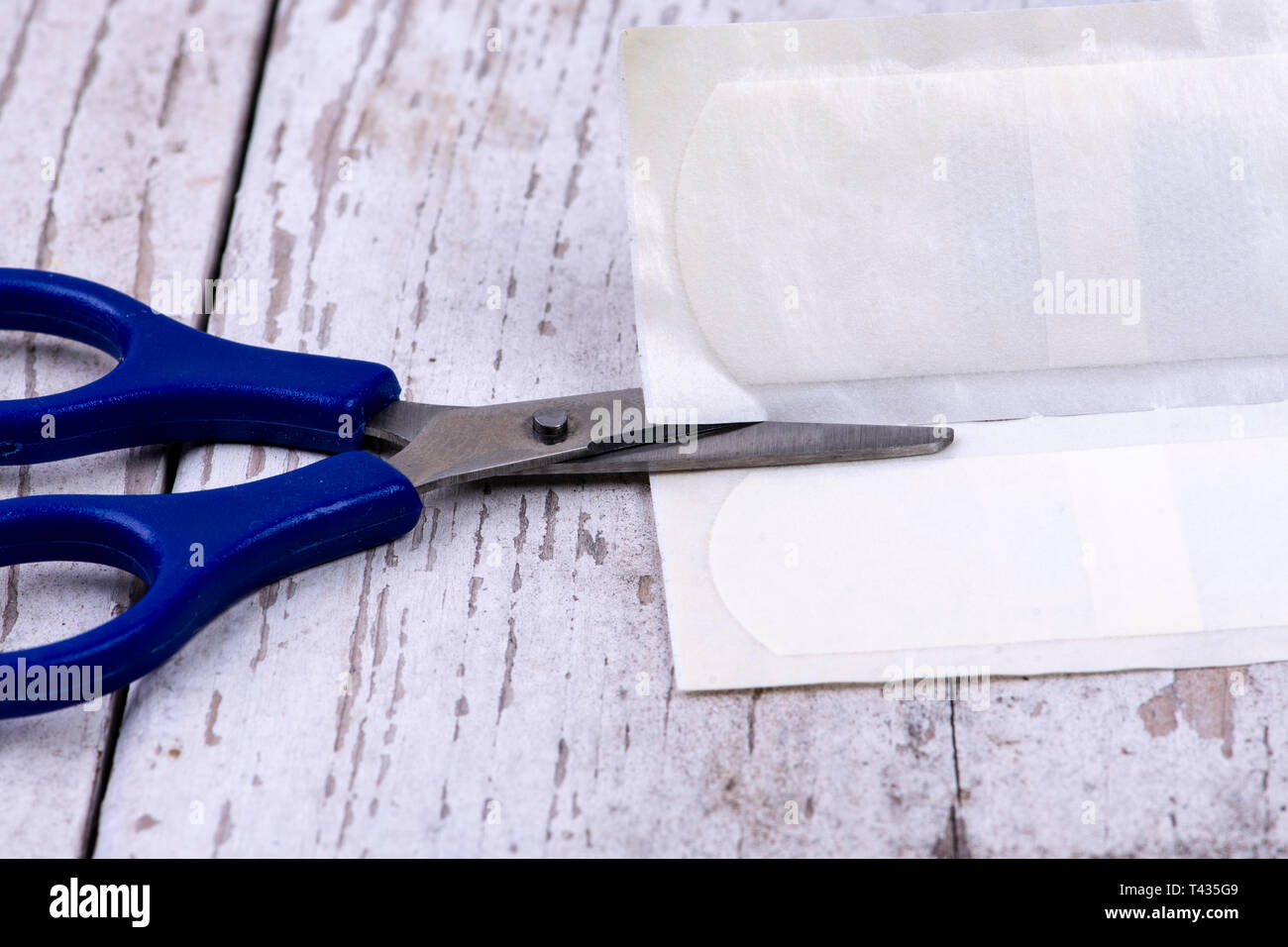 blue scissors cuts a plaster open Stock Photo - Alamy