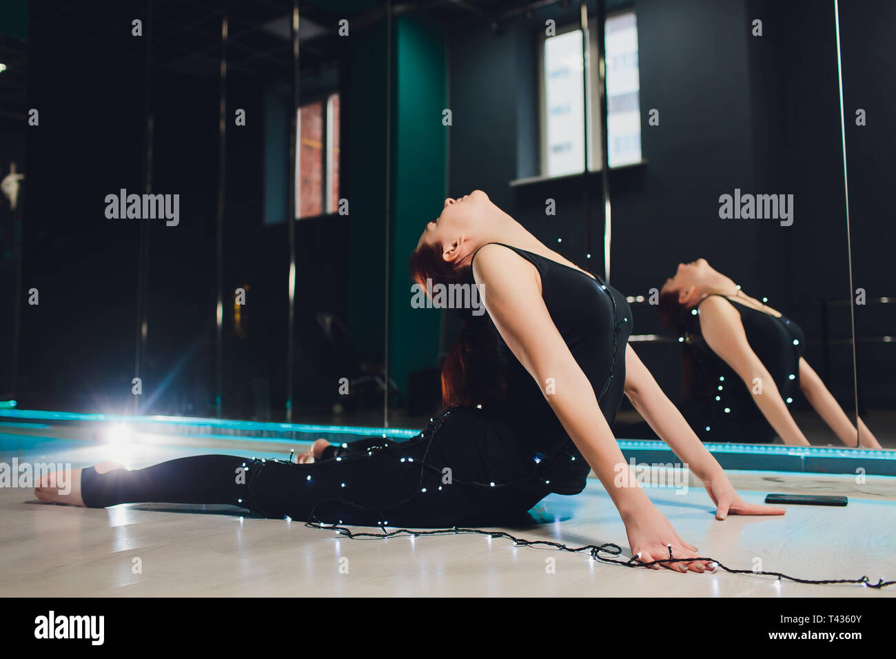 The girl gymnast the light of the garlands. Good night Stock Photo - Alamy